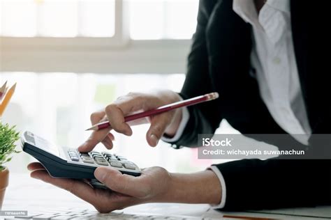 계산기에서 작업하는 사업가 또는 회계사 손 잡고 펜을 닫아 사무실 비즈니스 개념에서 비즈니스 데이터 회계 문서 및 랩톱 컴퓨터를