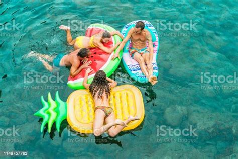 Lilos 매트리스와 함께 떠 있는 행복 한 친구 바다 자연 수영장젊은 유행 사람들 여름 휴가에서 재미 있는 수영청소년 라이프 스타일 여행 및 파티 컨셉남자들의 얼굴에 집중