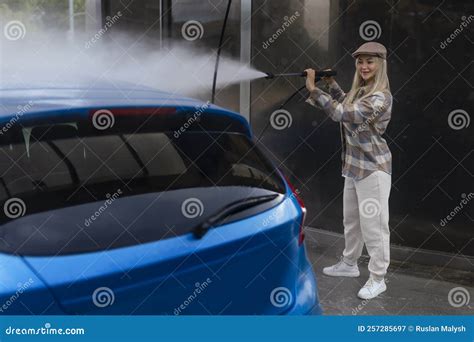 Woman Washing A Car In A Self Service Car Wash Station With Wahing Foam