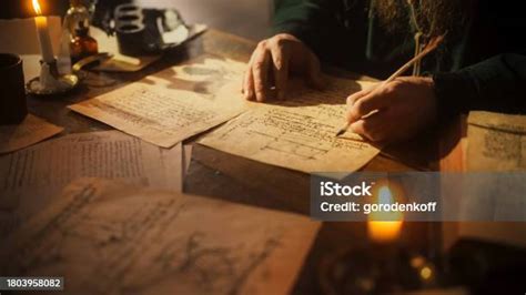 잉크와 깃펜을 사용하여 새로운 아이디어를 쓰는 오래된 르네상스 남성의 손으로 비문과 메모를 닫습니다 노트를 작성하고 새로운 이론을 발명하고 혁신하는 헌신적인 역사가 쓰기에