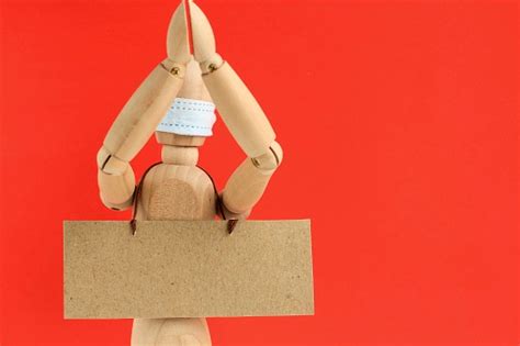 의료 용 마스크에 나무 인형이나 마네킹에 매달려 텍스트를위한 공간이있는 골판지 표지판 반 인종 주의의 개념 사회적 거리 검역