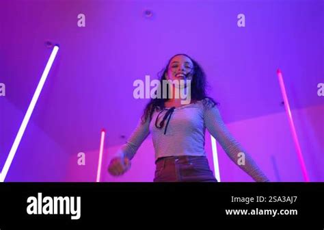 Low Angle Camera Of Hispanic Dancer Looking At Camera And Dancing To City Pop Music