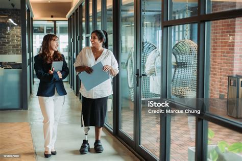 디지털 태블릿과 메모장을 들고 있는 두 명의 아시아 다민족 미소 사업가 손 사무실 복도에서 걷기 장애에 대한 스톡 사진 및 기타 이미지 Istock