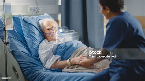 병원 병동 친절한 머리 간호사는 침대에서 휴식 산소 마스크를 착용하는 노인 환자에게 손가락 심박수 모니터 또는 펄스 옥시미터를 연결합니다 간호사는 성공적인 수술 후 환자