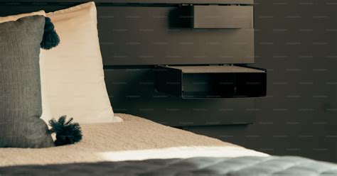 깔끔하게 정돈된 침대와 벽 조명이 있는 침실 사진 Unsplash의 미니멀 홈 이미지