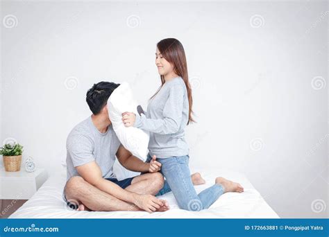 Asian Couples Tease Each Other On The Bed In The Bedroom Stock Image