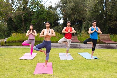 Premium Photo Female Instructor Teaching Tree Pose To Men And Woman