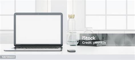 빈 노트북 화면 소모품 및 기타 물건이 있는 넓은 흰색 사무실 바탕 화면을 닫습니다 흐릿한 콘크리트 벽과 창문을 배경으로 도시 전망을 감상할 수 있다 모형 3d 렌더링