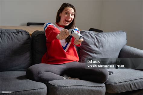 집에서 무선 게임 패드와 비디오 게임을 하는 여자 콘솔 게임 홈 레저 활동 밀레니엄 세대의 집 검역 라이프 스타일 Brand Name Video Game에 대한 스톡 사진