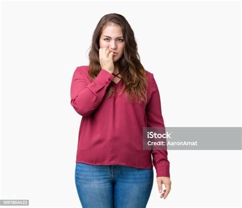 격리 된 배경 위에 크기 젊은 여자 플러스 아름 다운 찾고 스트레스와 긴장에 입에 물고 손으로 손톱 불안 문제입니다 갈색 머리에