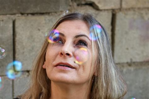 Premium Photo Close Up Of Young Woman Blowing Bubbles