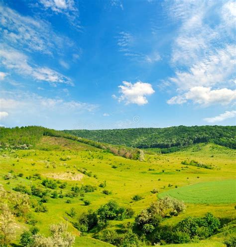 Hilly Green Field And Windmill On Blue Sky Background Stock Image