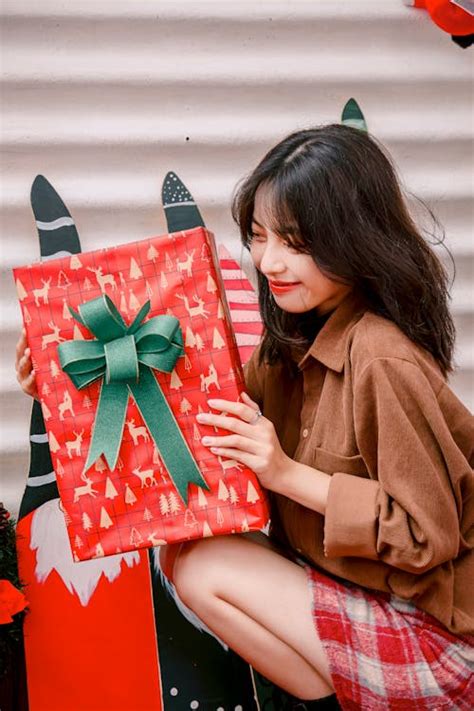 실내 2023년 크리스마스 갈색 스웨터 감싸 인 선물 검은 머리 겨울 겨울 방학 계절 기쁨 녹색 활 미소