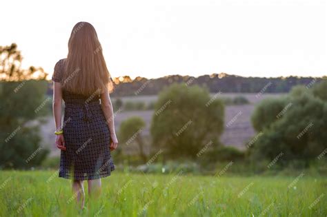 Premium Photo Young Woman Standing Alone On A Field With Green Grass