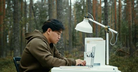 Man Using Laptop While Writing In Notebook · Free Stock Video