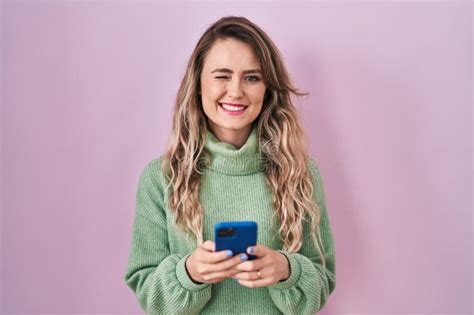 Young Caucasian Woman Using Smartphone Typing Message Winking Looking