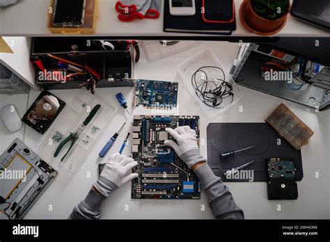 technician working on installation of cpu into disassembled computer sitting at his desk in