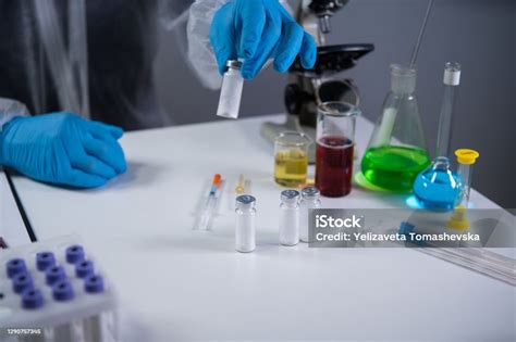 백색 분말 불법 약국 생산 약물앰프를 들고 과학자 실험실 도우미는 주사를 위해 유리 의료 앰플을 검사합니다 페니실린 드라이 파우더 약 항생제 주입 Stem 주제에 대한 스톡