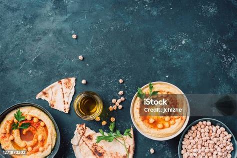병아리콩 허머스 올리브 오일 생 병아리콩 훈제 파프리카 어두운 배경에 피타 중동 유대인 요리 또는 아랍 요리 맨 위 보기입니다 공간을 복사합니다 스낵 세트 비건 채식 식품