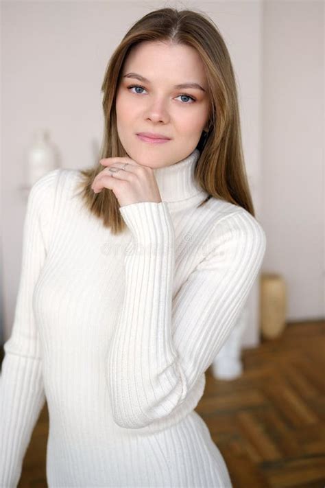 Portrait Of A Beautiful Elegant Brown Haired Woman In A Light Knitted Dress With A High Neck