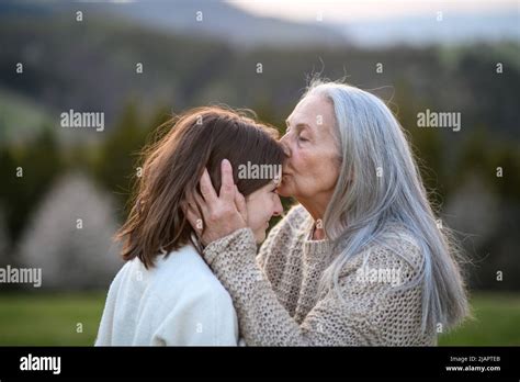 Happy Senior Grandmother Kissing Her Teenage Granddaguhter On Forehead