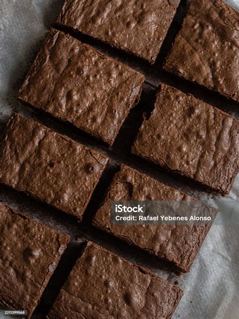 갓 만든 브라우니를 나무 테이블 위의 베이킹 페이퍼에 조각으로 자릅니다 0명에 대한 스톡 사진 및 기타 이미지 0명 가정 생활 가정 주방 Istock
