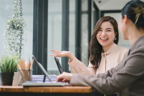 Two Professional Millennial Asian Startup Businesspeople Are Discussing Evaluation Data In A