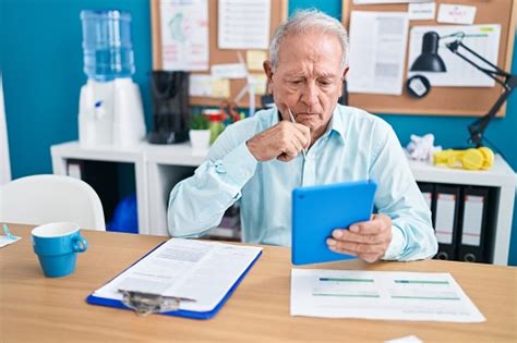 사무실에서 진지한 표정으로 터치패드를 사용하는 중년 회색 머리 남자 비즈니스 노동자 노인 남자에 대한 스톡 사진 및 기타 이미지 노인 남자 노인 비즈니스 Istock