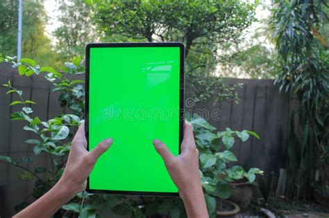 a hand holding a tablet pc in portrait orientation like playing game
