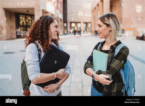 Two College Students Talking Two Students Talking In Class Hi Res