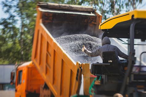 도로 건설 및 수리 작업 중 아스팔트 포장 기계 및 증기 도로 롤러 아스팔트 및 포장 과정 새로운 도로 건설 현장에서 일하는 근로자 층 배치 무인 항공기 개발에 대한 스톡