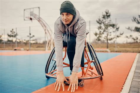 휠체어를 탄 젊은 농구 선수가 스포츠 훈련 전에 야외 코트에서 스트레칭 운동을 하고 있다 사진 Unsplash의 성인 이미지
