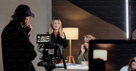 스튜디오에서 여성 모델과 함께 광고를 촬영하는 동안 스테디캠 앞에 서 있는 젊은 비디오그래퍼의 뒷모습 사진 Unsplash의