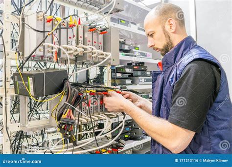 Man Switches Audio And Video Cable On The Patch Panel Worker Works On The Control Panel In The