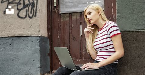 흰색과 빨간색 줄무늬 셔츠와 파란색 데님 청바지를 입은 여자가 콘크리트 벤치에 앉아 사진 Unsplash의 무료 컴퓨터 이미지