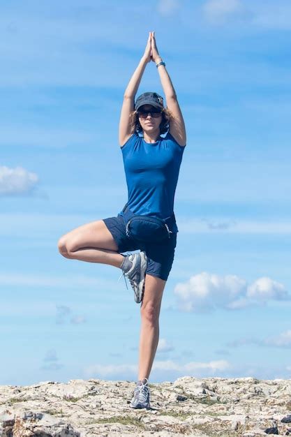 Premium Photo The Girl Is Engaged In Yoga On A Background Of Cloudy Sky Tree Pose