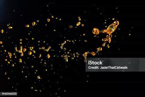 오렌지 레몬 주스 또는 오일 윤활유 스플래시 액체 골드 노란색 음료 방울 선 형태의 과일 음료 물 요소 신선한 튀고 흐르는 제트기 검은 배경 격리 된 동결 동작 가솔린에