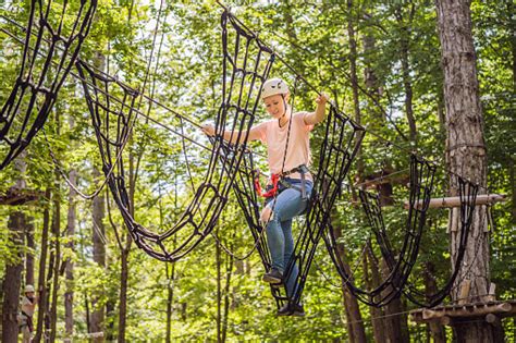 행복 한 여성 소녀 여성 활공 등반 익스트림로드 트롤리 지퍼 라인 숲 카라 비너 안전 링크 나무 상단 로프 어드벤처 파크에 있습니다 가족 주말 어린이 어린이 활동 개념 카페