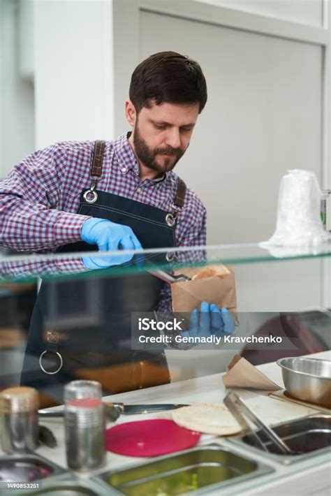 피타 자이로 샌드위치를 요리하는 젊은이 유럽 카페에서 전통적인 그리스 패스트푸드 요리를 준비하는 요리사 40 49세에 대한 스톡