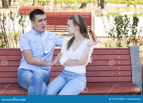 Pares Jovenes Felices En El Amor Que Se Sienta En Un Banco De Parque Foto De Archivo Imagen De