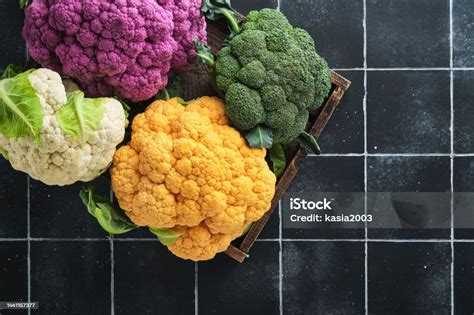 콜로푸 콜리플라워 오래 된 돌 타일 검은 콘크리트 배경에 콜리 플라워의 다양 한 종류 보라색 노란색 흰색 및 녹색 양배추 브로콜리와 로마네스코 농업 수확 모의 0명에 대한