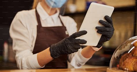 흰색 태블릿으로 바 카운터에 서 있는 보호막과 고무 장갑을 낀 여성의 자른 사진 사진 Unsplash의 복사 공간 이미지