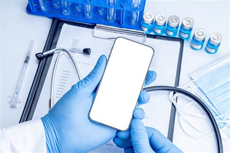 휴대 전화 모형 바늘 병원 의료 차트 의사 청진기 및 검은 색 스마트 폰이있는 주사기는 클리핑 경로가있는 의료 장비 배경을위한 빈 화면이있습니다 Brand Name