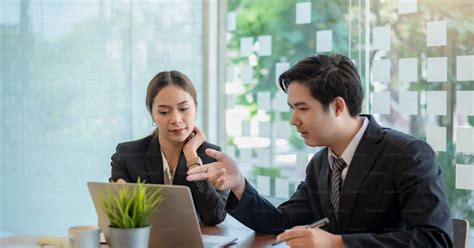 두 명의 젊은 아시아 비즈니스 동료가 사무실에서 노트북 컴퓨터로 새로운 프로젝트를 함께 작업하고 있습니다 사진 Unsplash의 종업원 이미지