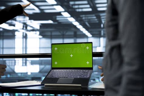 System Administrators In Data Center Using Green Screen Mockup Notebook