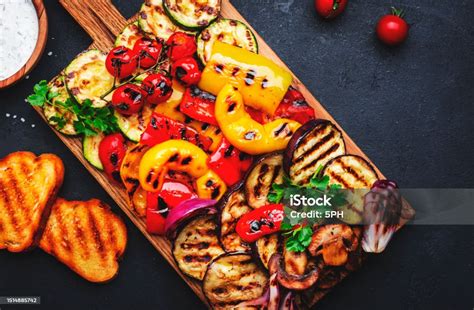 소박한 나무 도마에 구운 야채 화려한 파프리카 호박 가지 버섯 토마토 적양파와 요구르트 드레싱 검은 돌 테이블 배경 탑 뷰 0명에 대한 스톡 사진 및 기타 이미지 Istock