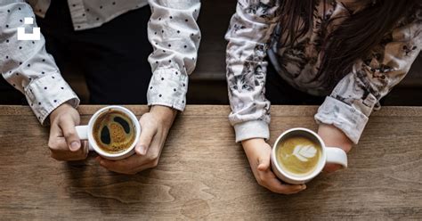 나무 테이블 위에 커피 잔을 들고 있는 두 사람 사진 Unsplash의 무료 브루클린 이미지