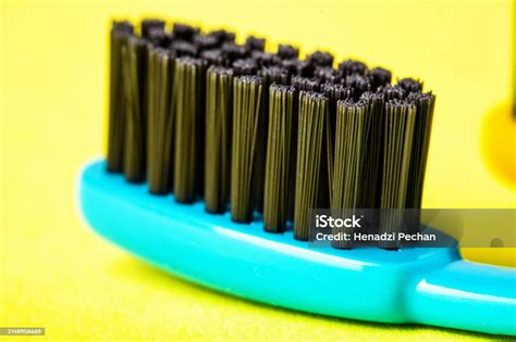 노란색 배경에 검은색 숯 코팅이 된 파란색 칫솔 구강 관리 및 치과 위생 개념 충치 거대 구강 예방 0명에 대한 스톡 사진 및