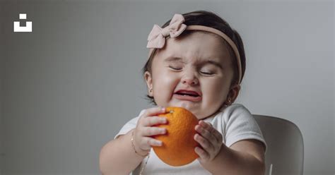 유아용 의자에 앉아 오렌지를 먹는 아기 사진 Unsplash의 무료 아기 이미지