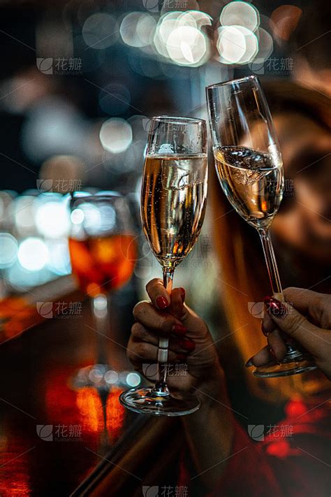 酒吧里的姑娘们用起泡酒碰杯和朋友们碰杯夜总会的气氛手的特写